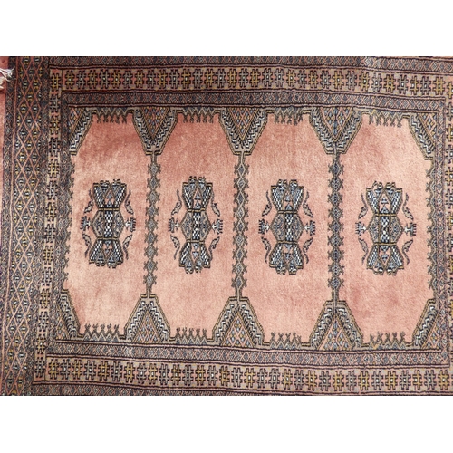 A Persian Bokhara design rug, decorated with four medallions, bordered ...