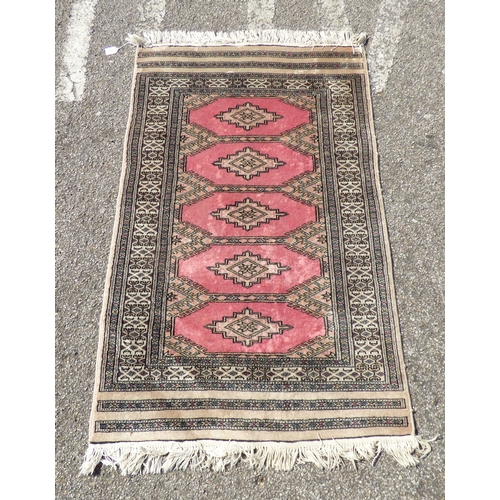 A Persian Bokhara design rug, decorated with five medallions, bordered ...