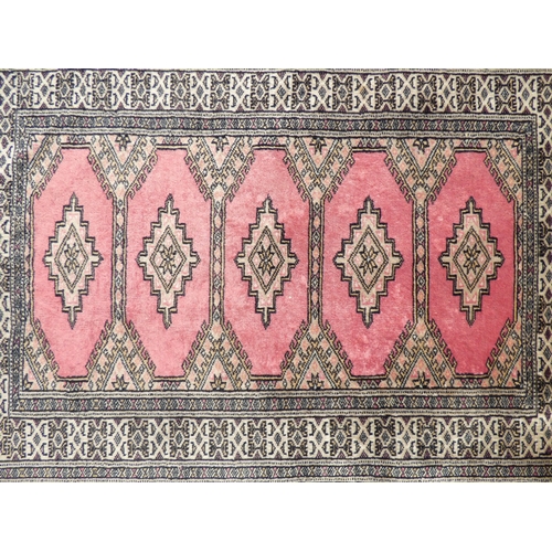 A Persian Bokhara design rug, decorated with five medallions, bordered ...