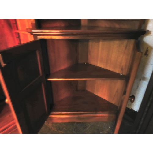 An Ercol Golden Dawn elm corner unit with a glazed open shelf and pair ...