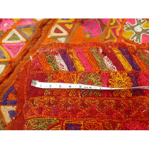 An Iraqi rug, decorated with geometric motifs, on a multi-coloured ...