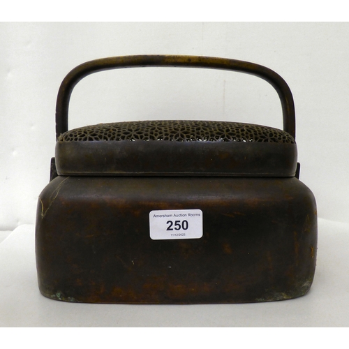 An early 20thC Japanese cast metal hand warmer with a swing handle and ...