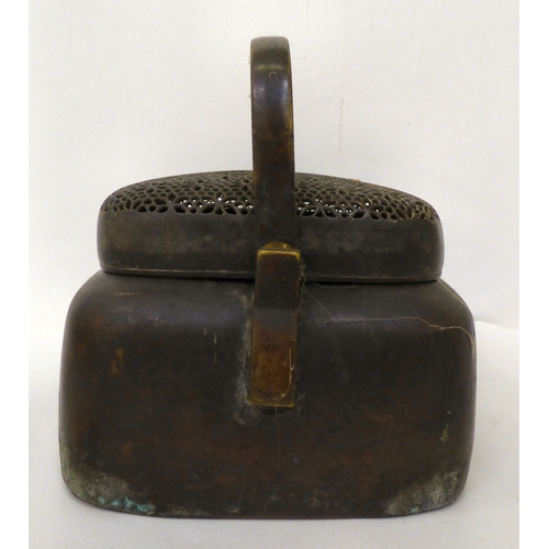 An early 20thC Japanese cast metal hand warmer with a swing handle and ...