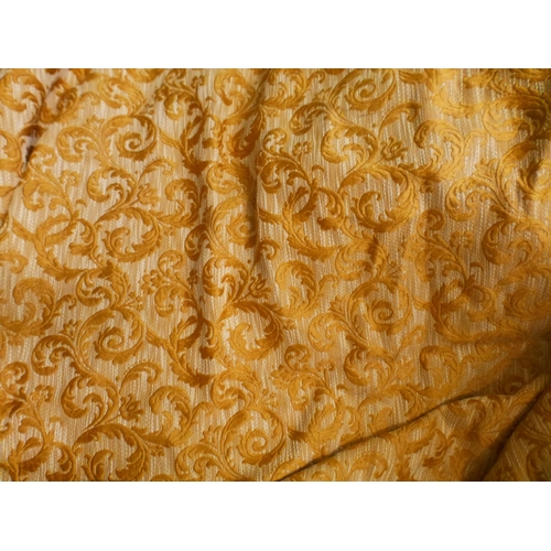 Two dissimilar patterned old gold coloured fabric throws