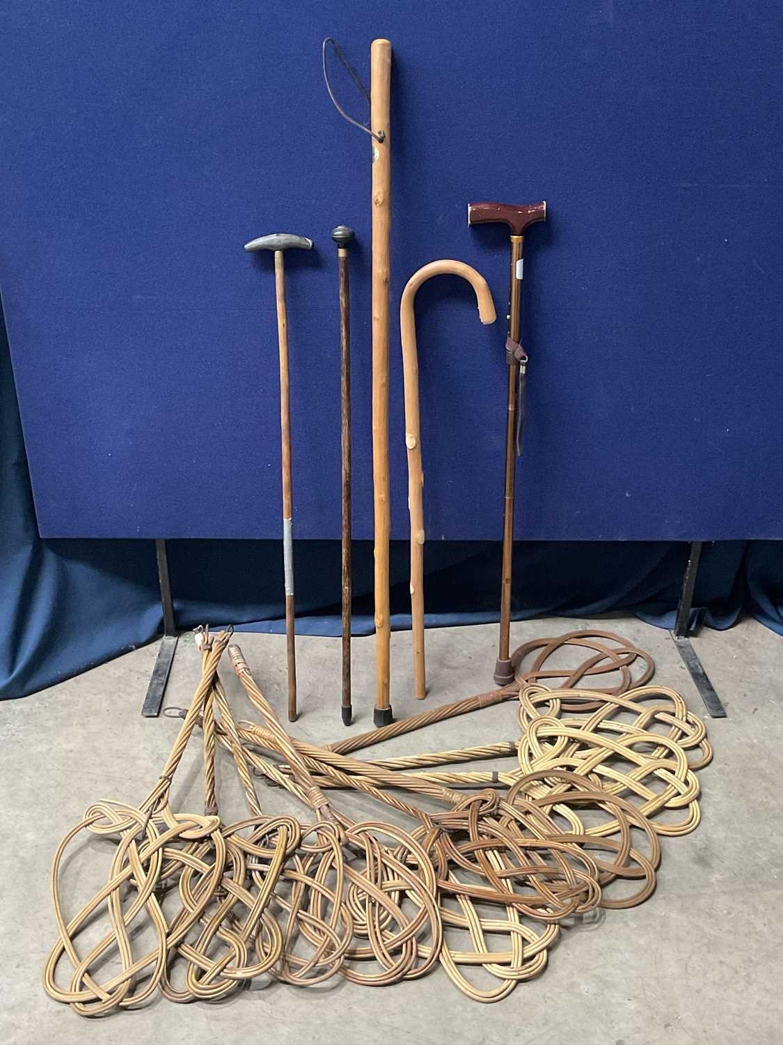 A collection of Victorian cane carpet beaters, walking sticks etc