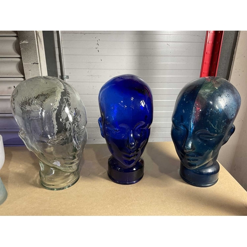 Three 20th century moulded glass display heads, approx 30cm high (3)