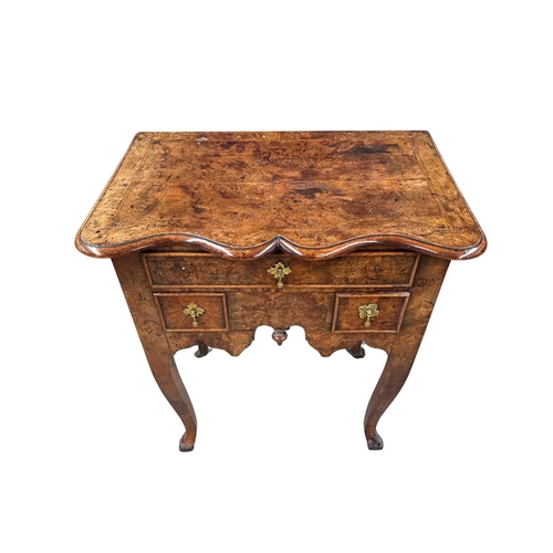 A George 1 walnut lowboy, on slight cabriole legs down to square pad ...