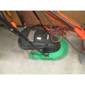 A small POWERBASE hover mower, working