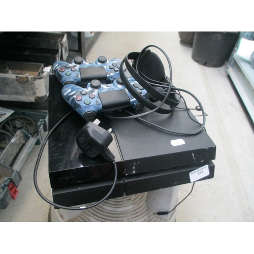 PS4 with two controllers and headphones