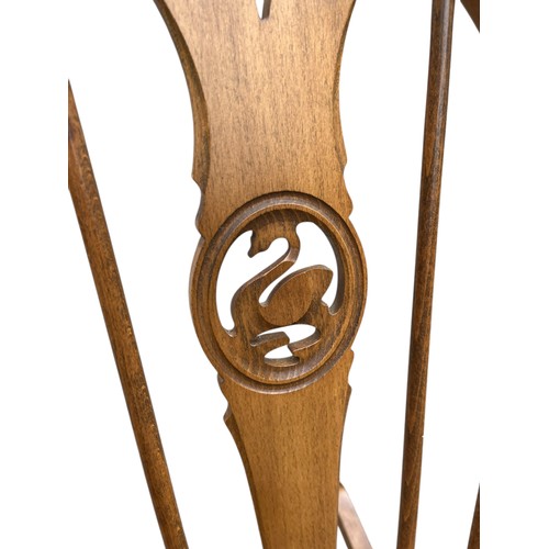 A QUALITY ERCOL OAK ROCKING CHAIR WITH SWAN TO CENTRE