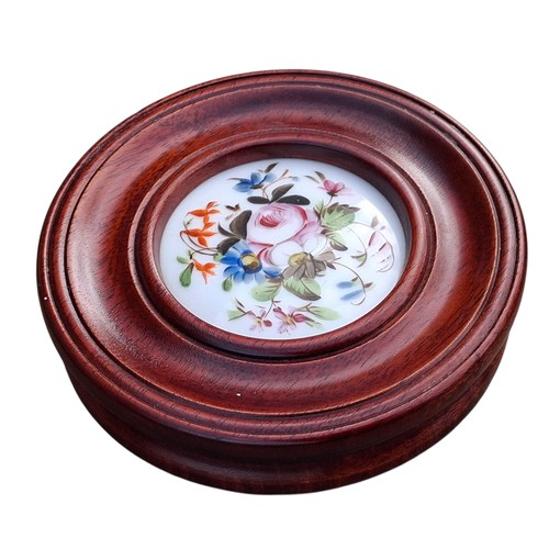 AN EARLY HAND PAINTED POT LID FRAMED