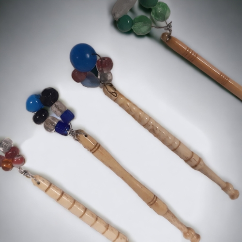 A COLLECTION OF FOUR VICTORIAN BONE LACE BOBBINS. WITH GLASS BEADS.