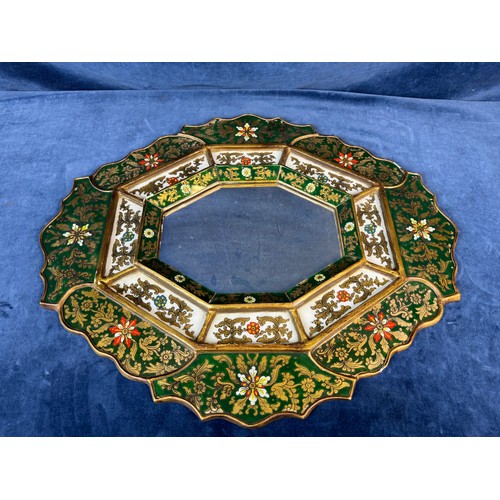 A vintage hand crafted reverse painted mirror having floral decoration.