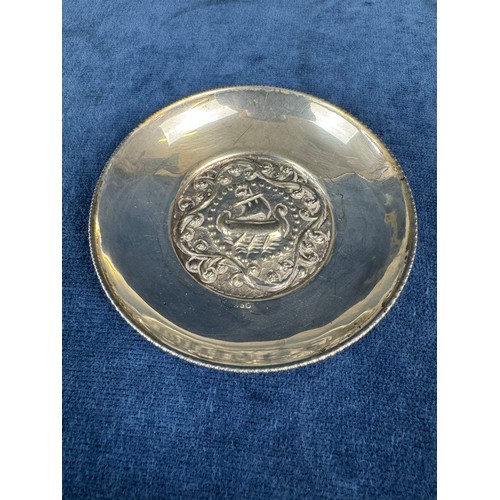 A small circular dish with central image of a boat with floral surround ...