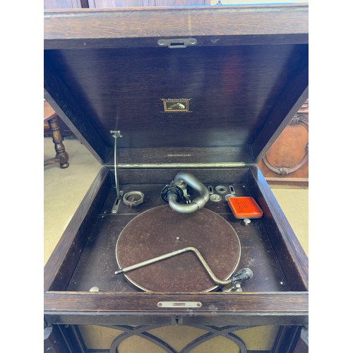 A vintage 'His Master's Voice' gramophone in oak case, with lift top ...