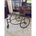 An antique tubular steel 3-wheeled walking frame with arm supports.