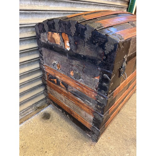 A large domed top trunk with wooden strapping and ornate catches ...