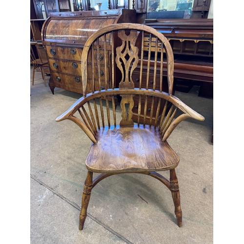 An elm Windsor armchair on shaped stretcher and turned legs, with ...