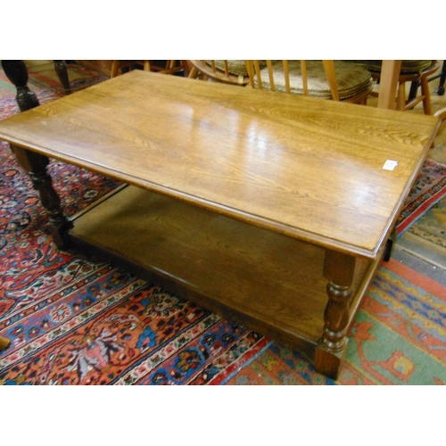 An oak rectangular coffee table, on baluster supports joined by an ...