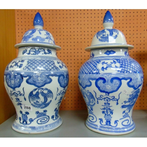 Pair of reproduction blue and white lidded vases, having traditional ...