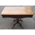 A Victorian fold over tea table, raised on carved legs