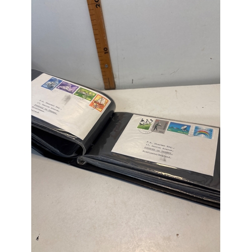 Binder with assorted postcards featuring stamps and written messages.