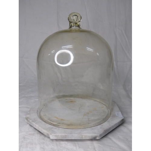 An antique glass dome on marble base. Measuring approx 40cm tall.
