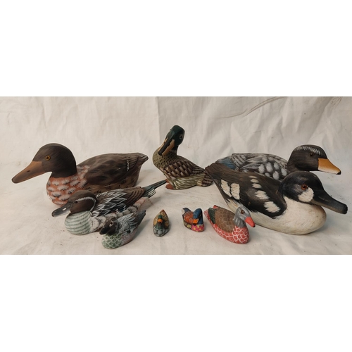 A collection of wood and ceramic ducks.