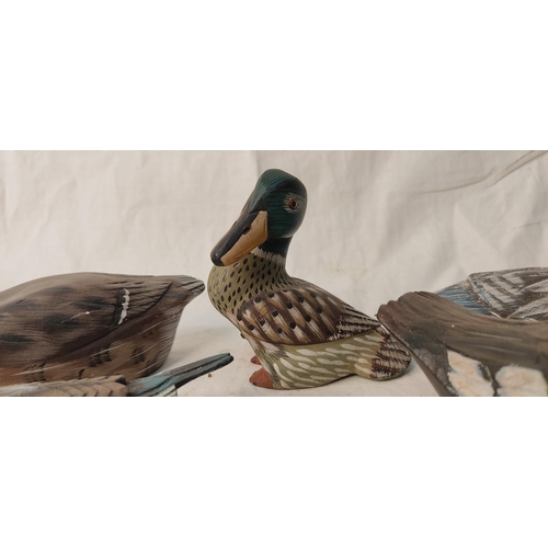 A collection of wood and ceramic ducks.