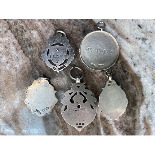 A collection of 5 antique Sterling Silver fobs.