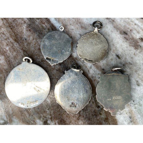 A collection of 5 antique Irish & Sterling Silver fobs.