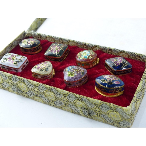 A cased set of eight miniature enamel pill boxes.