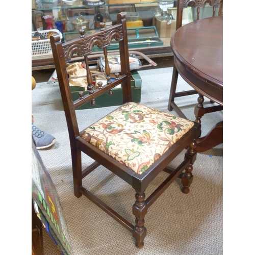 A circular dining room table and four Ercol chairs.
