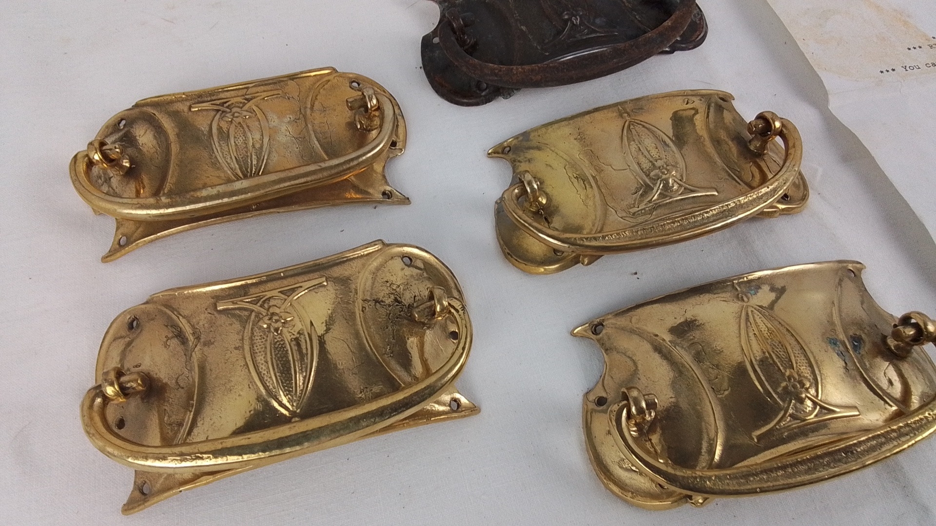 Set of five Art Nouveau-style brass drawer pulls, each with a swing ...
