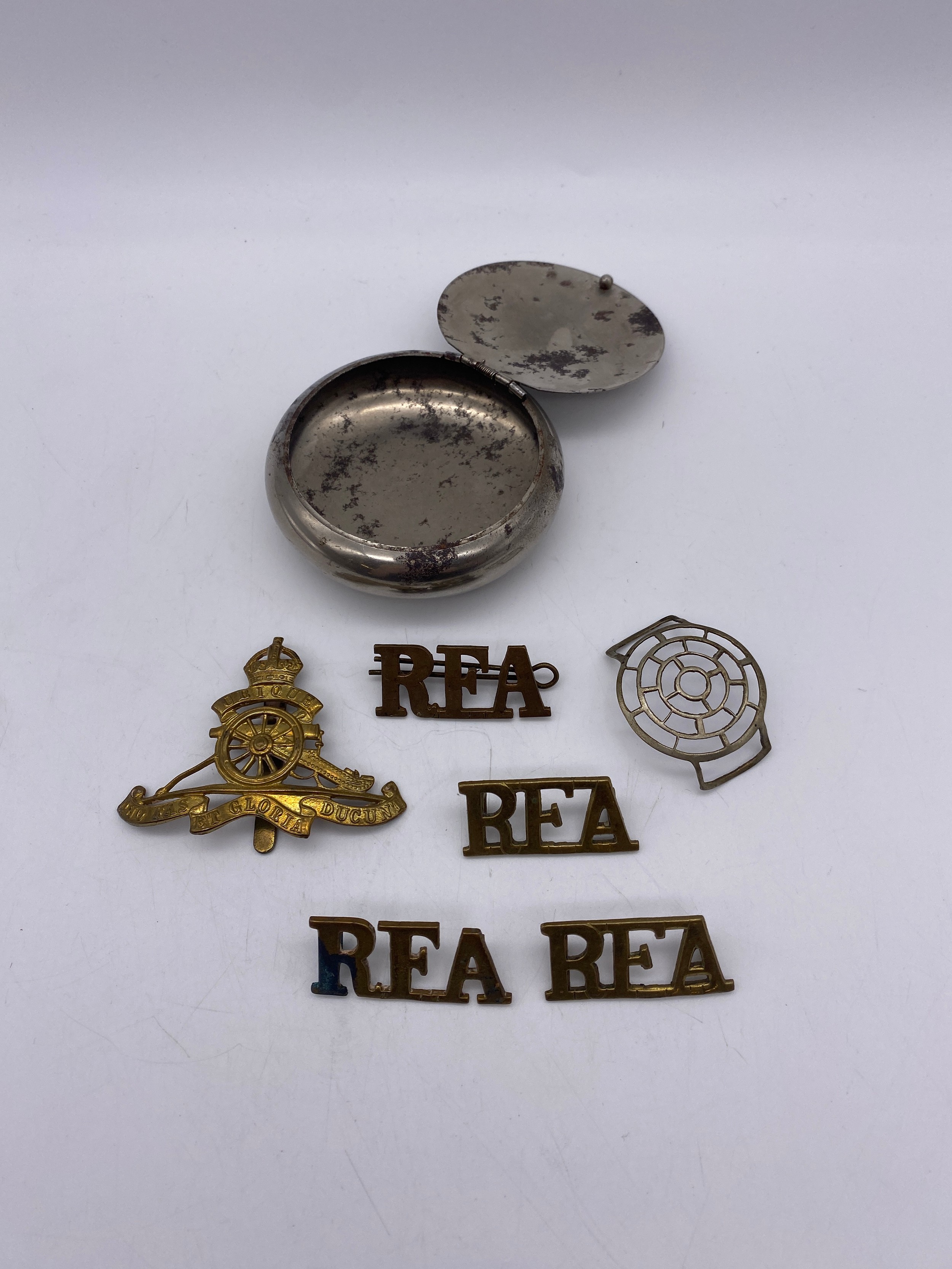 MILITARY REGIMENTAL RFA CAP BADGES AND A CIRCULAR TOBACCO BOX