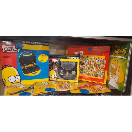 TWO SHELVES OF THE SIMPSONS RELATED ITEMS, WALL CLOCK, SHOWER SET, MUGS ...