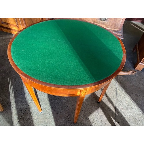 A Sheraton mahogany half round card table, the folding top crossbanded ...