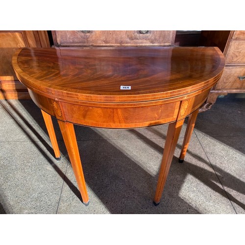 A Sheraton mahogany half round card table, the folding top crossbanded ...