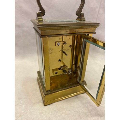 A modern carriage clock with gilt face, circular white dial, in a ...