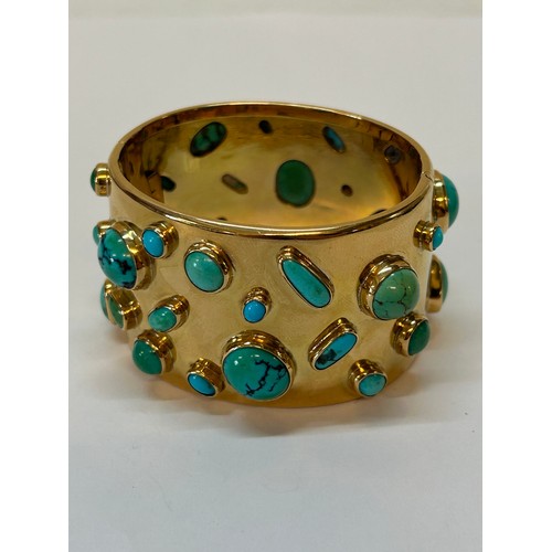 A heavy 18ct. gold bangle set turquoise cabochons, signed to the clasp ...