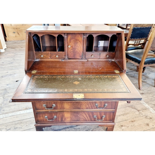 Reproduction mahogany bureau with fitted interior over a base of four ...