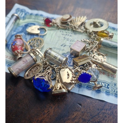 A fine collection of gold charms. To include encapsulated note charms ...