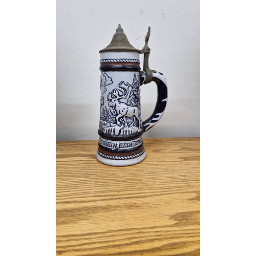 An attractive amd decorative ceramic beer tankard or stein with pewter lid