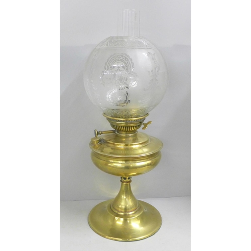 A Victorian brass messenger oil lamp with chimney and etched glass ...