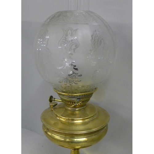 A Victorian brass messenger oil lamp with chimney and etched glass ...