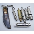 Six Boy Scout and Girl Guide whistles and a small dagger