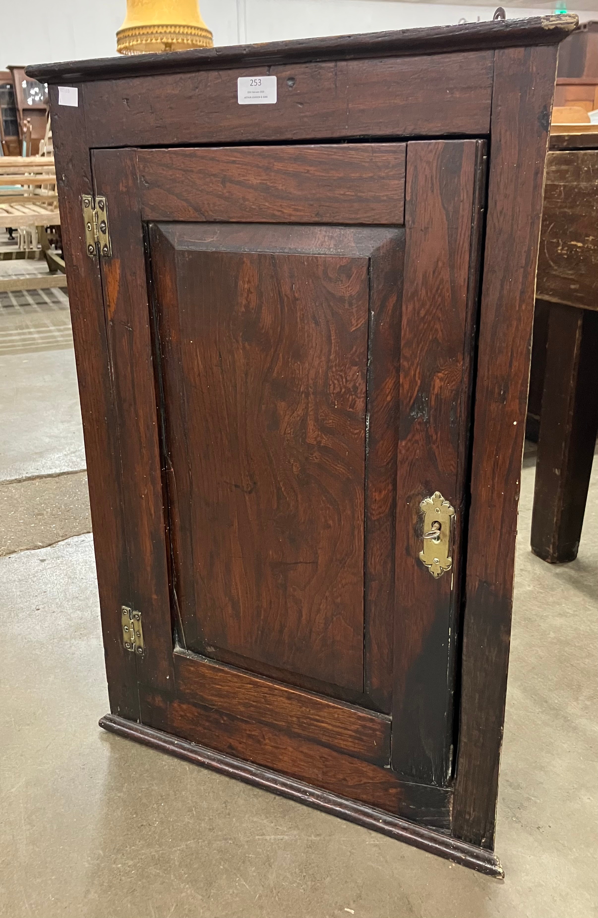 A George III oak splay front wall hanging corner cupboard