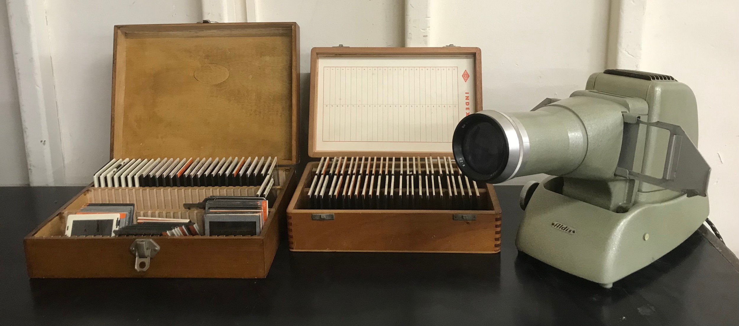 An Aldis slide projector and two boxes of photographic slides