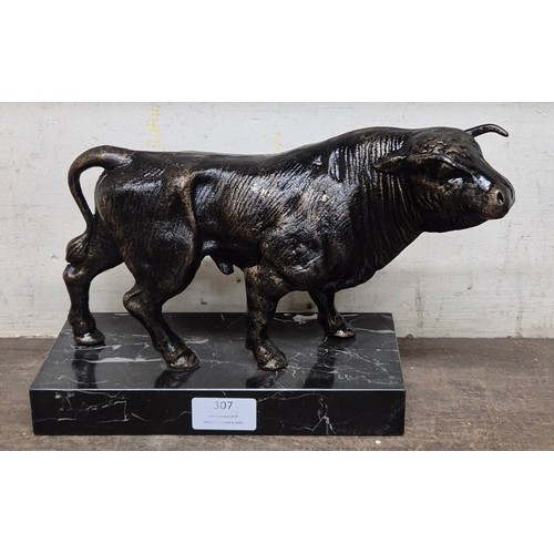 A bronze effect bull on black marble socle