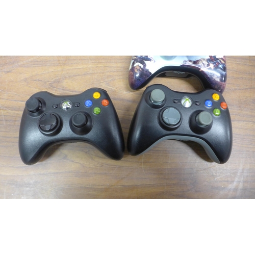 An Xbox 360 S console with three wireless Xbox 360 controllers ...